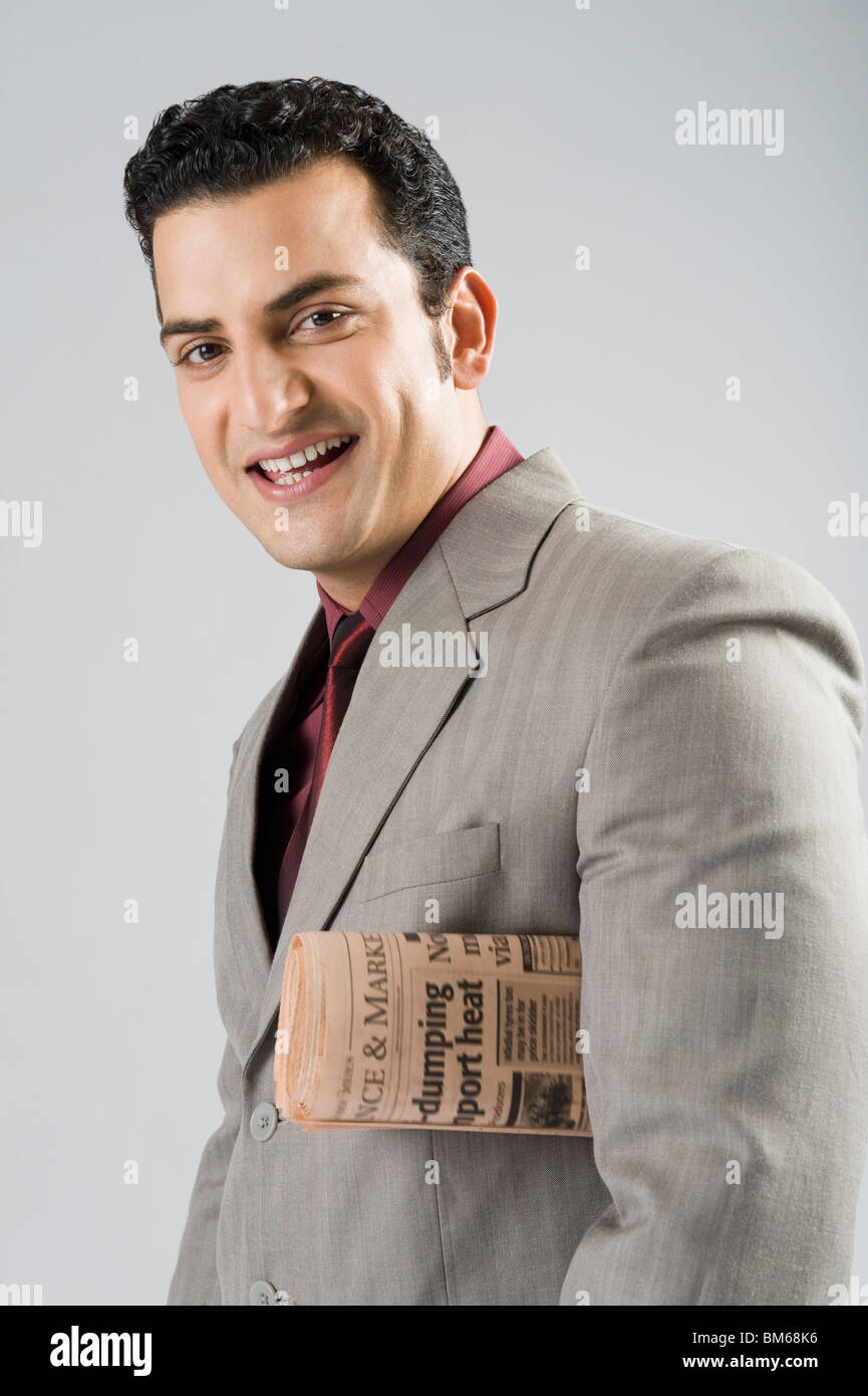 Businessman with a newspaper under his arm Stock Photo - Alamy