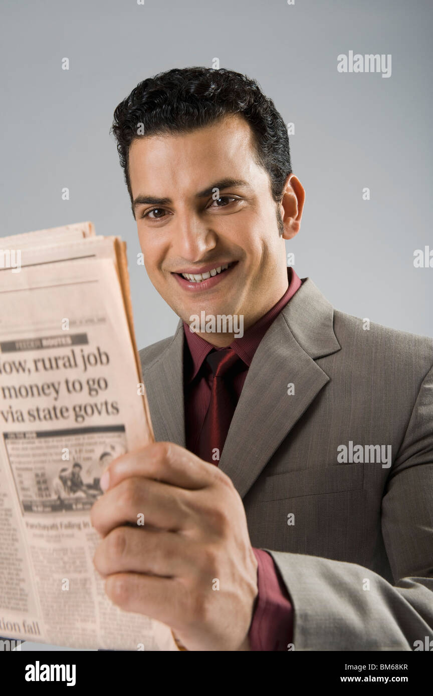 Businessman holding a newspaper Stock Photo - Alamy