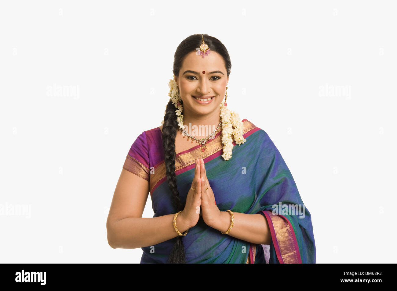 Woman making a greeting gesture and smiling Stock Photo - Alamy
