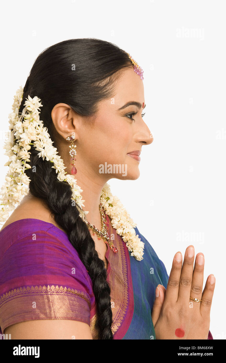 Woman making a greeting gesture and smiling Stock Photo - Alamy