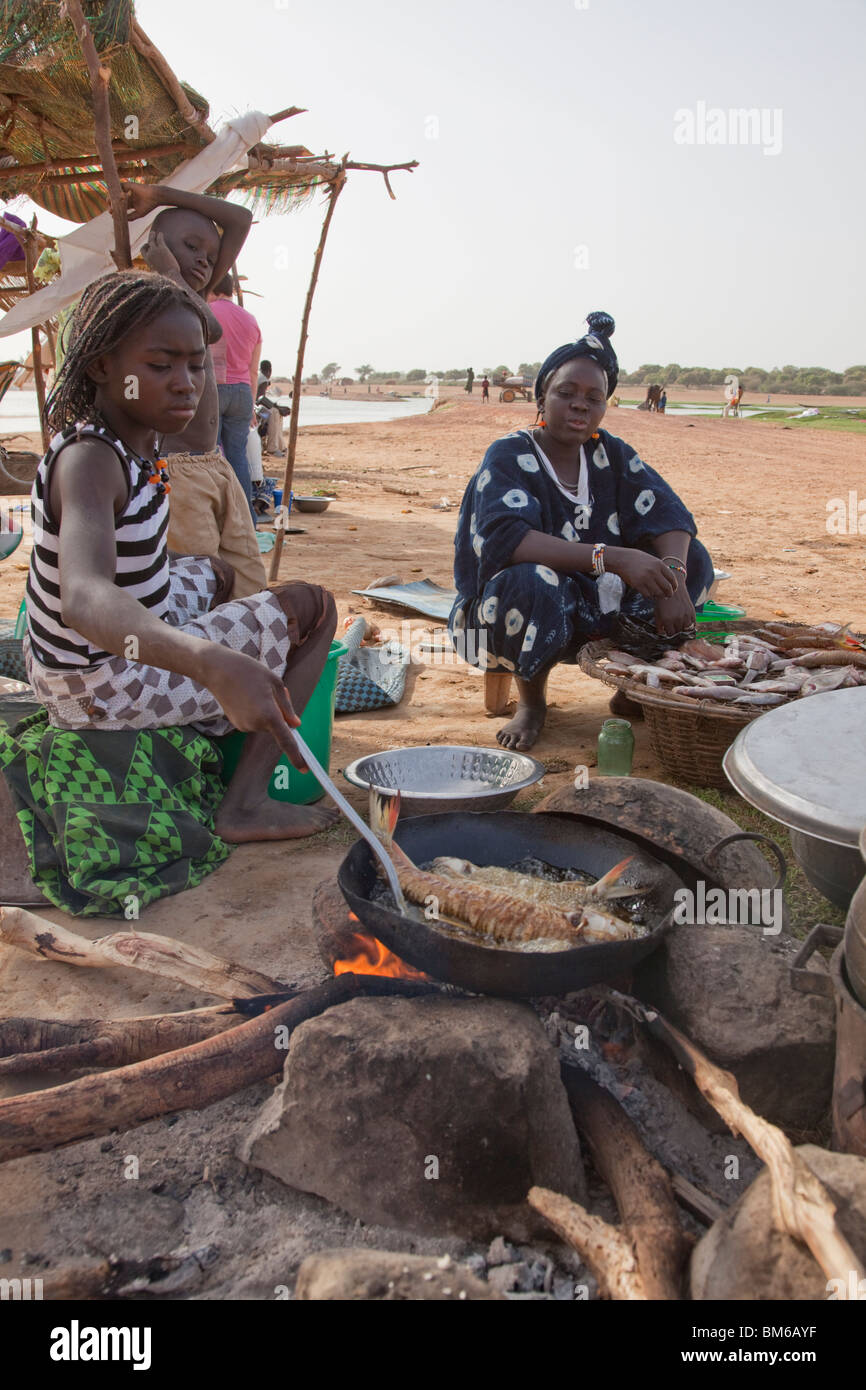 A woman sells fried fish to travelers at the ferry crossing to Djenne ...