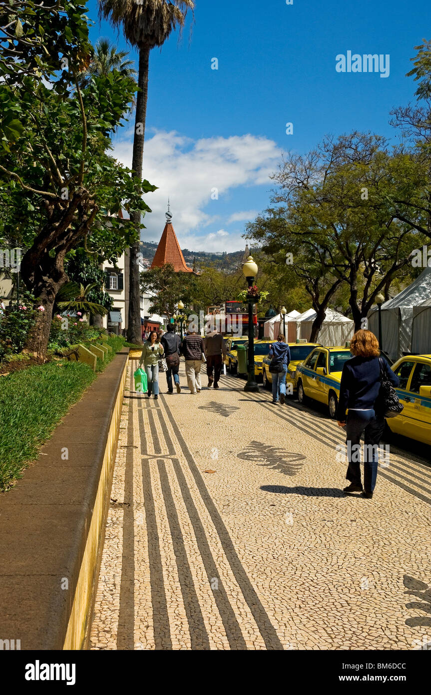Shoppers people tourists visitors walking along pavement sidewalk on ...