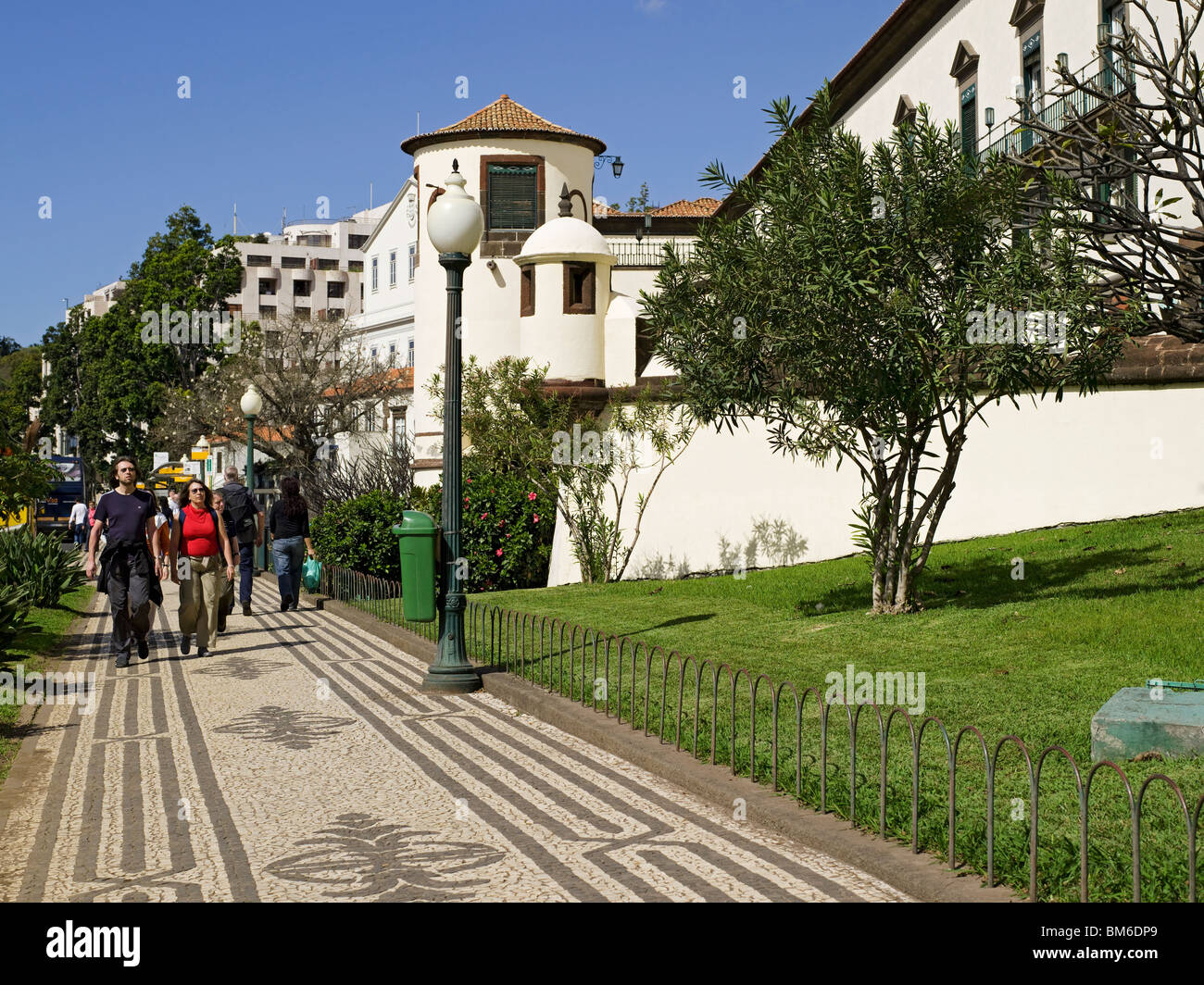 Tourists people visitors walking along decorated pavement outside ...