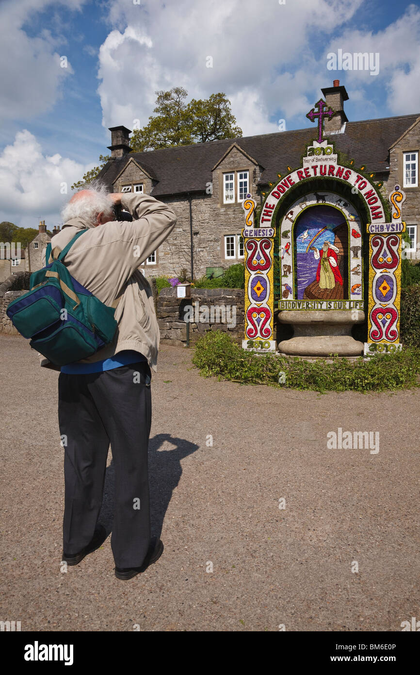 Tourist photographing a well dressing at Tissington, Peak District ...