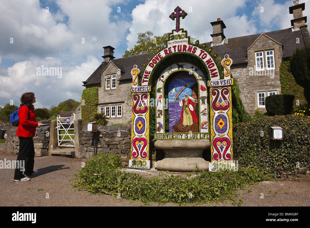 Visitor admiring a well dressing at Tissington, Peak District National ...