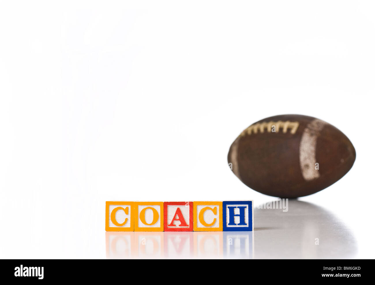 Colorful children's blocks spelling COACH with an American football in ...