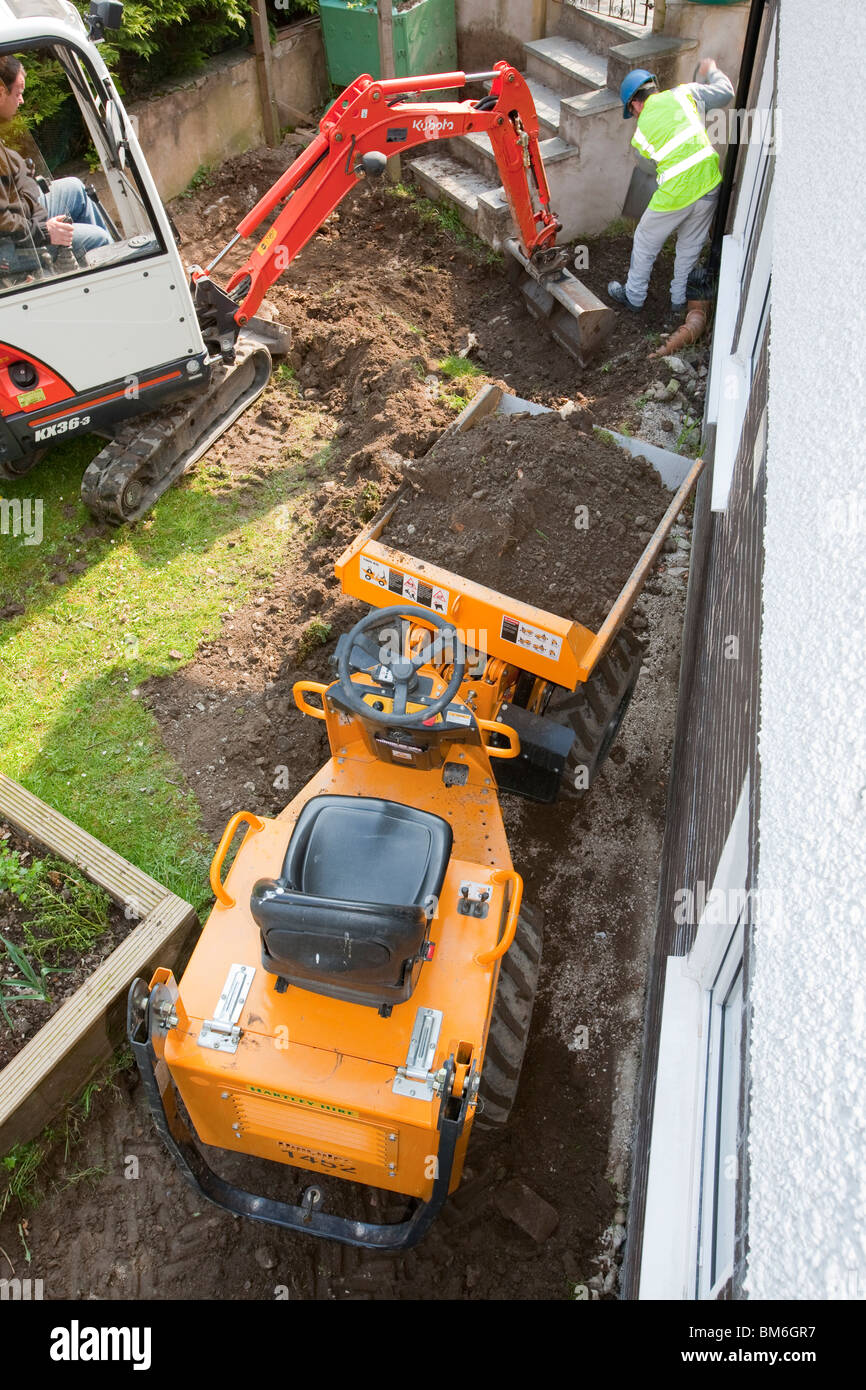 A mine digger and mini dumper truck on a house extension, building job ...