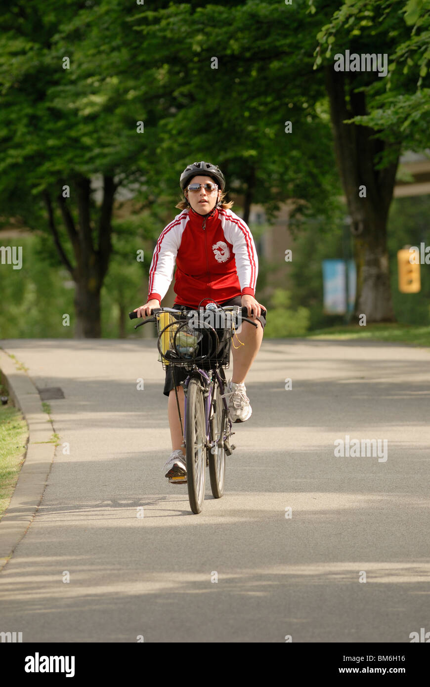 Frontal view of an adult woman riding a bicycle Stock Photo - Alamy