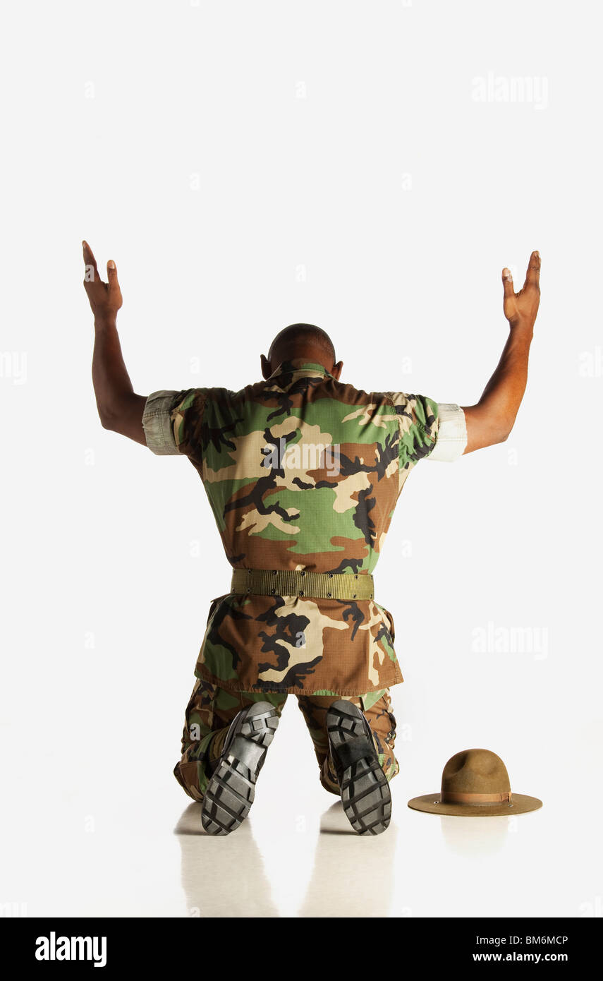 A Military Man Kneeling With Hands Raised Stock Photo - Alamy