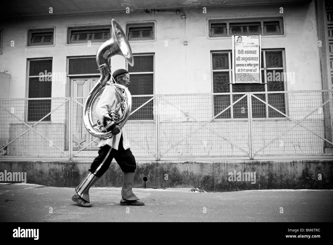 Indain man walking carrying a trombone Stock Photo - Alamy