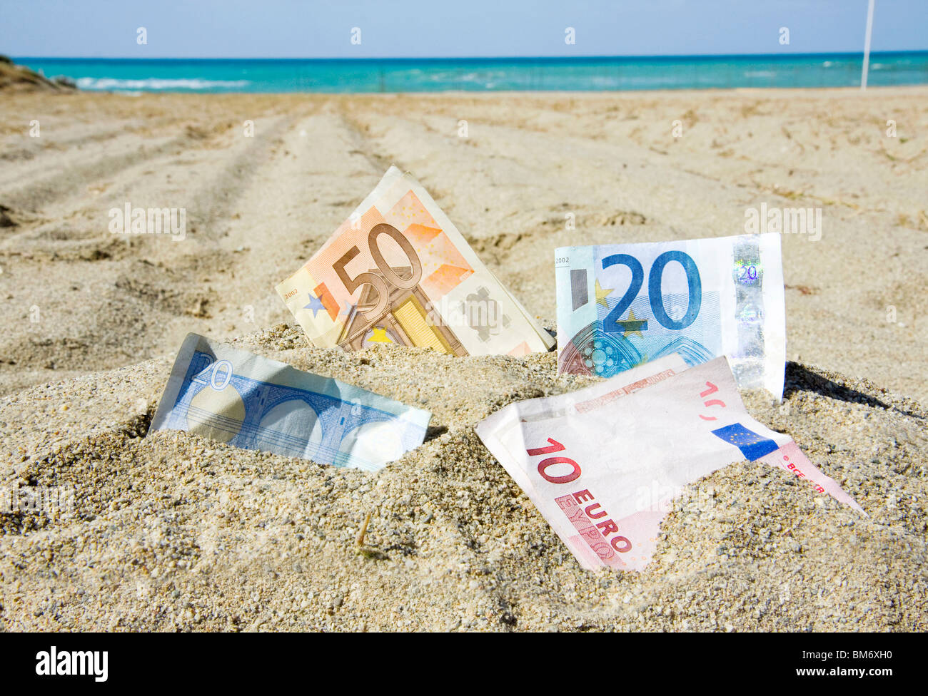 Money: Euro notes on beautiful beach. Euros in sand Stock Photo - Alamy