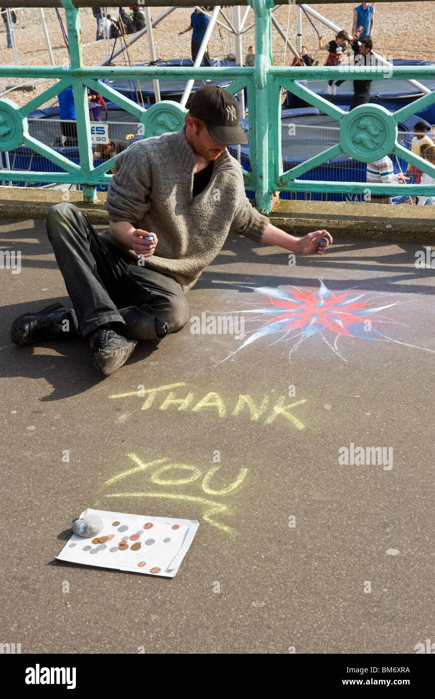 A pavement street artist using coloured chalks to create a chalk ...