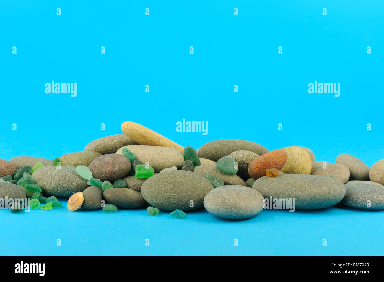 Pebble and sea glasses. On a bright blue background Stock Photo - Alamy