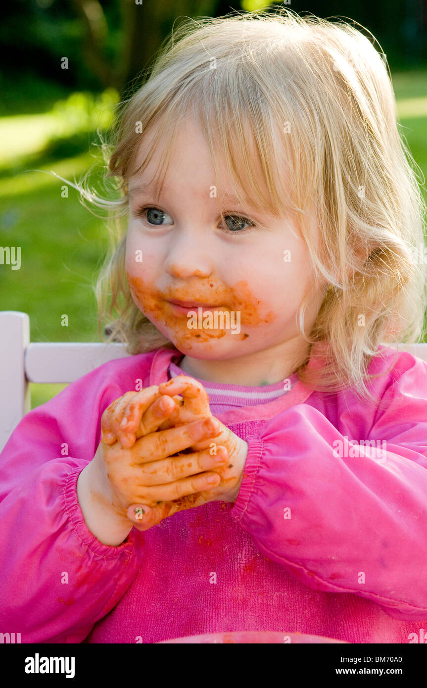 GIRL TODDLER, ENJOYS GETTING MESSY WHILE EATING PASTA IN TOMATO SAUCE ...