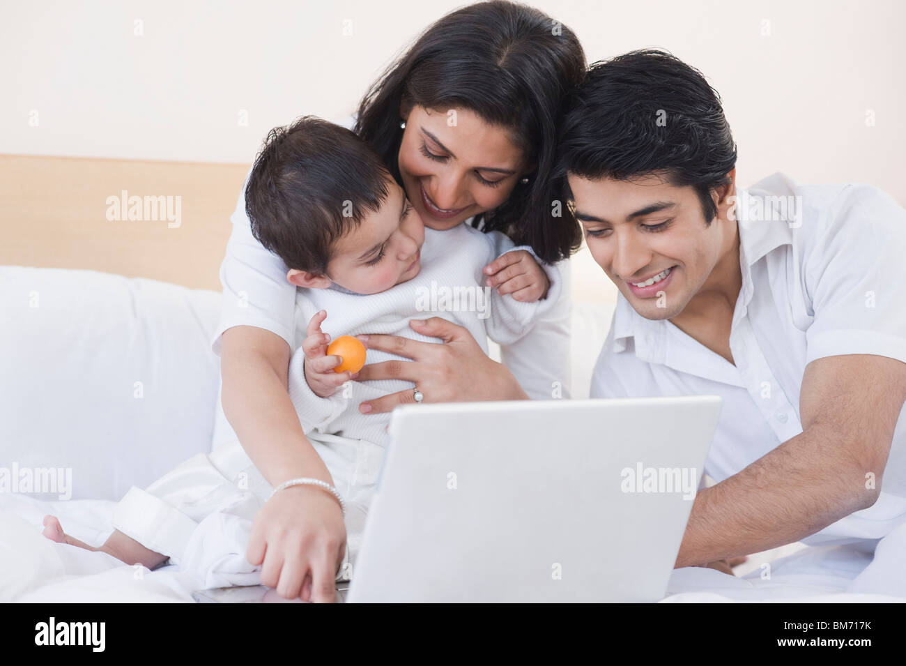 Parents using a laptop with their son Stock Photo - Alamy
