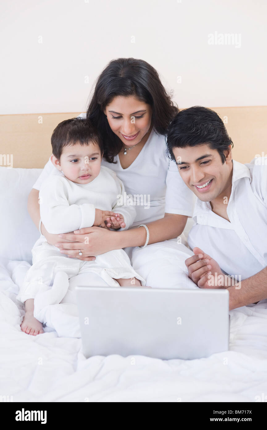 Parents using a laptop with their son Stock Photo - Alamy