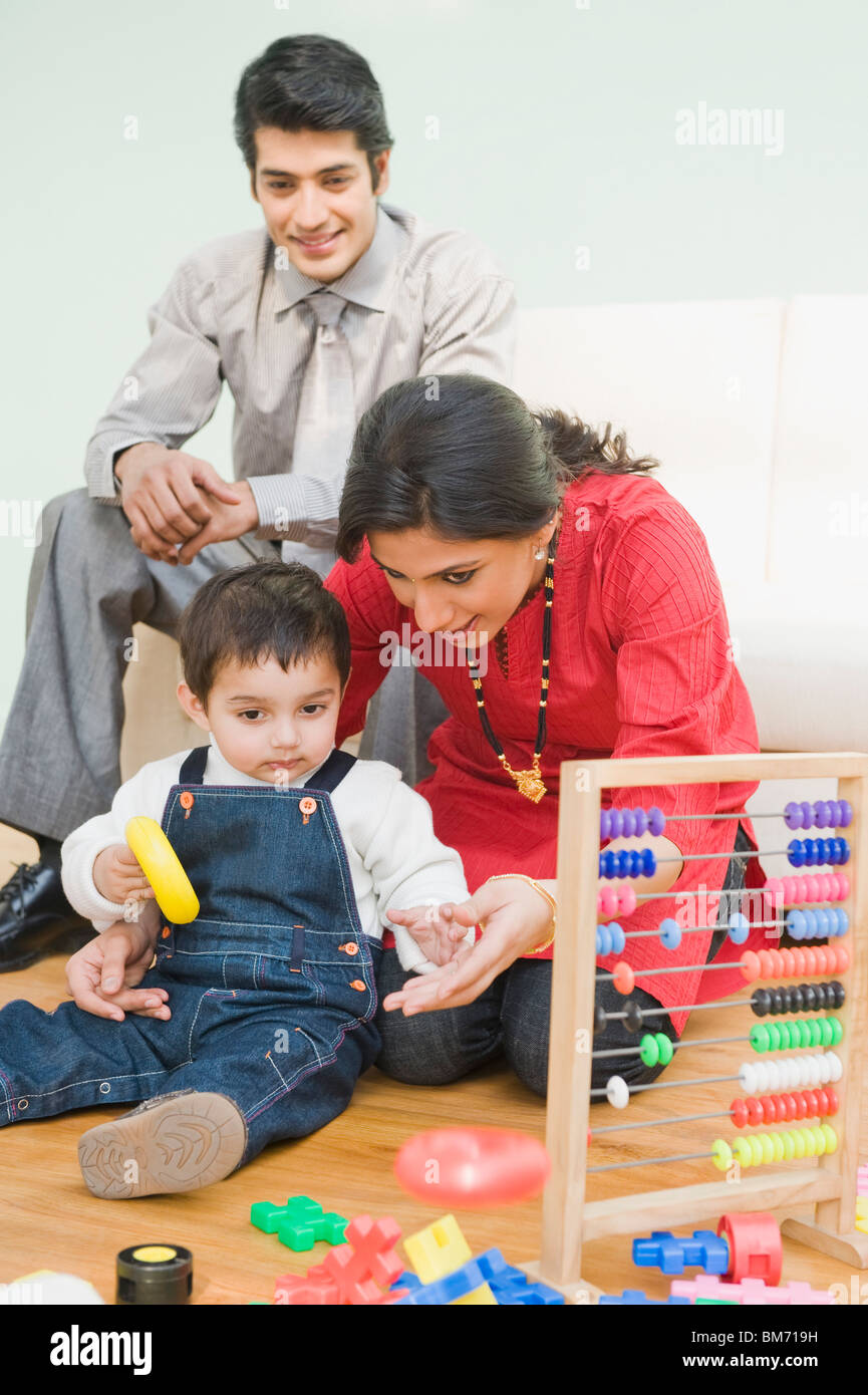 Baby boy playing toys with his parents Stock Photo - Alamy