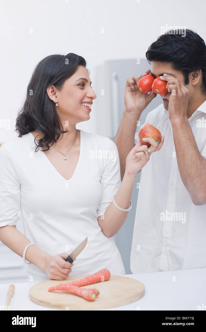 Couple making fun with vegetables in the kitchen Stock Photo - Alamy