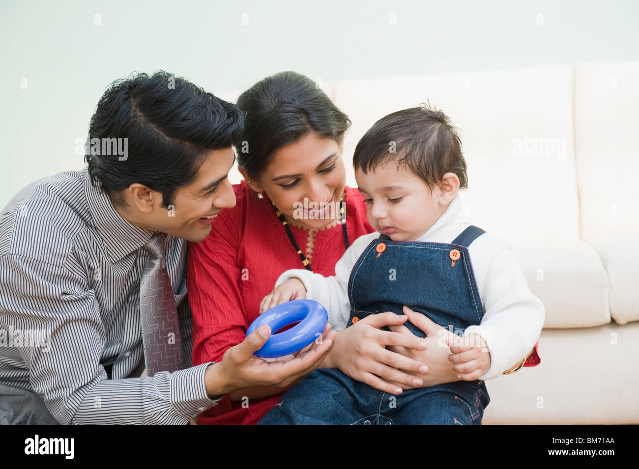Couple giving toy to their son Stock Photo - Alamy