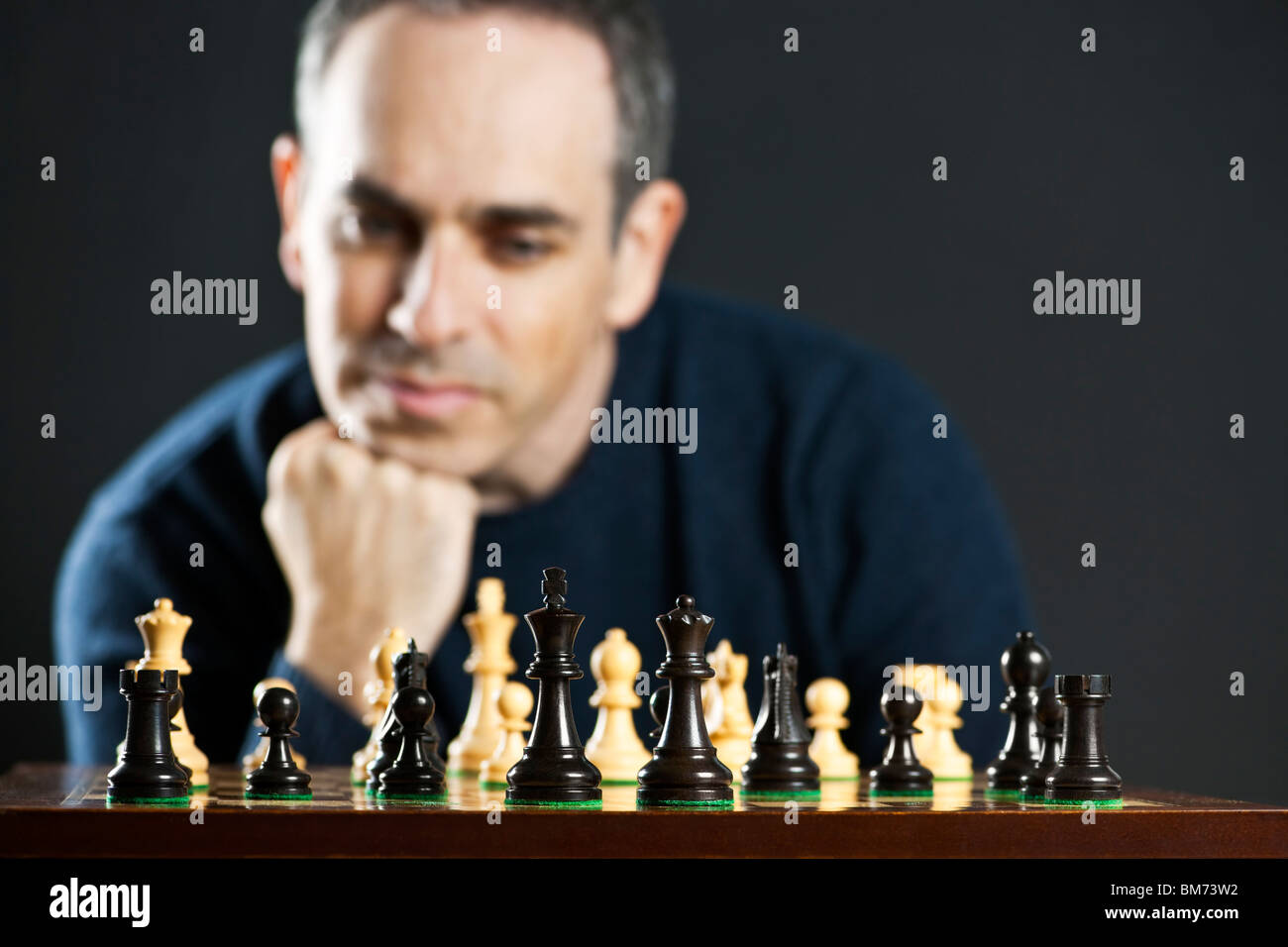 Chessboard with man thinking about chess strategy Stock Photo - Alamy