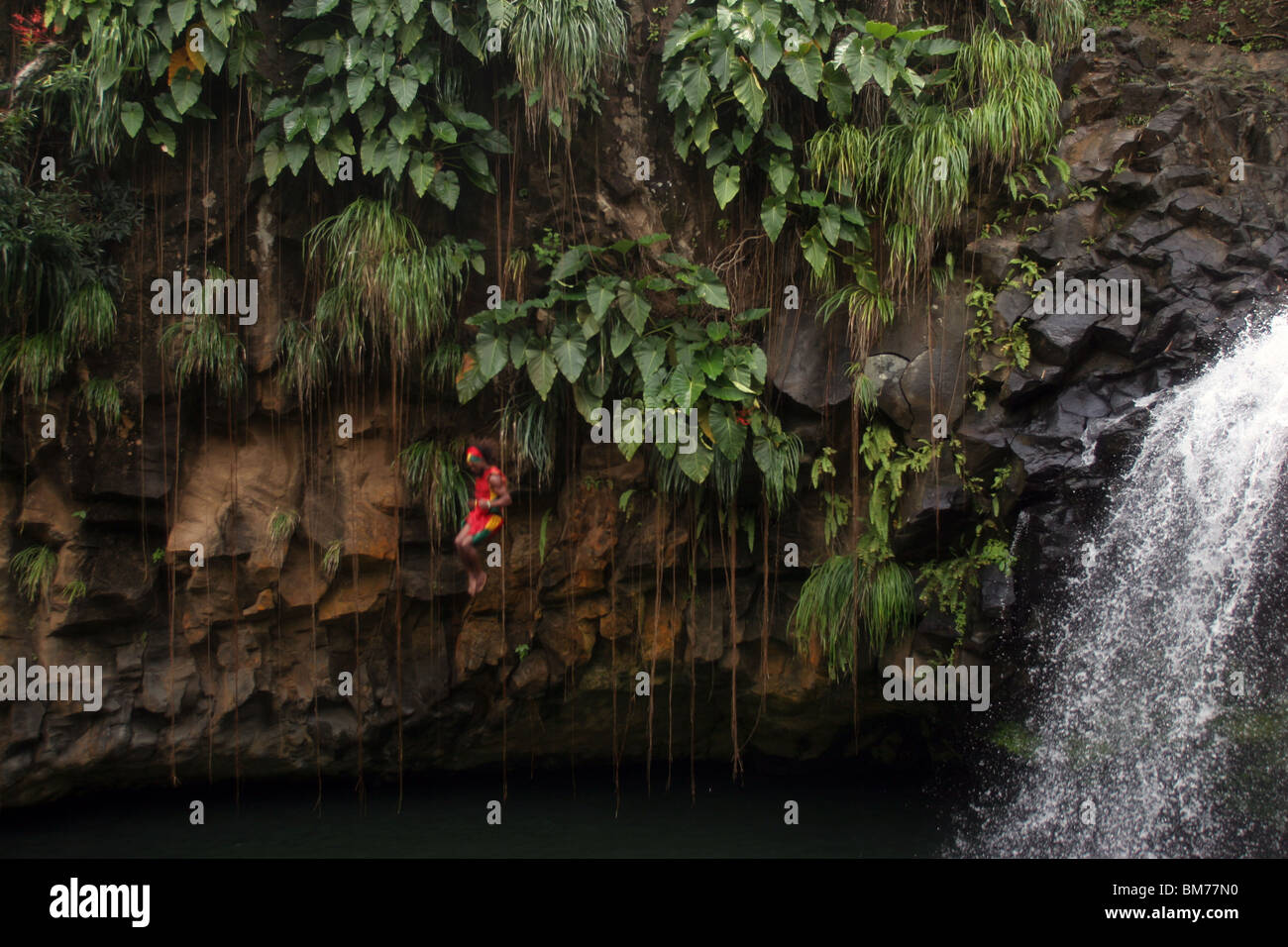 A man jumps into the water below a waterfall in Grenada, Caribbean ...