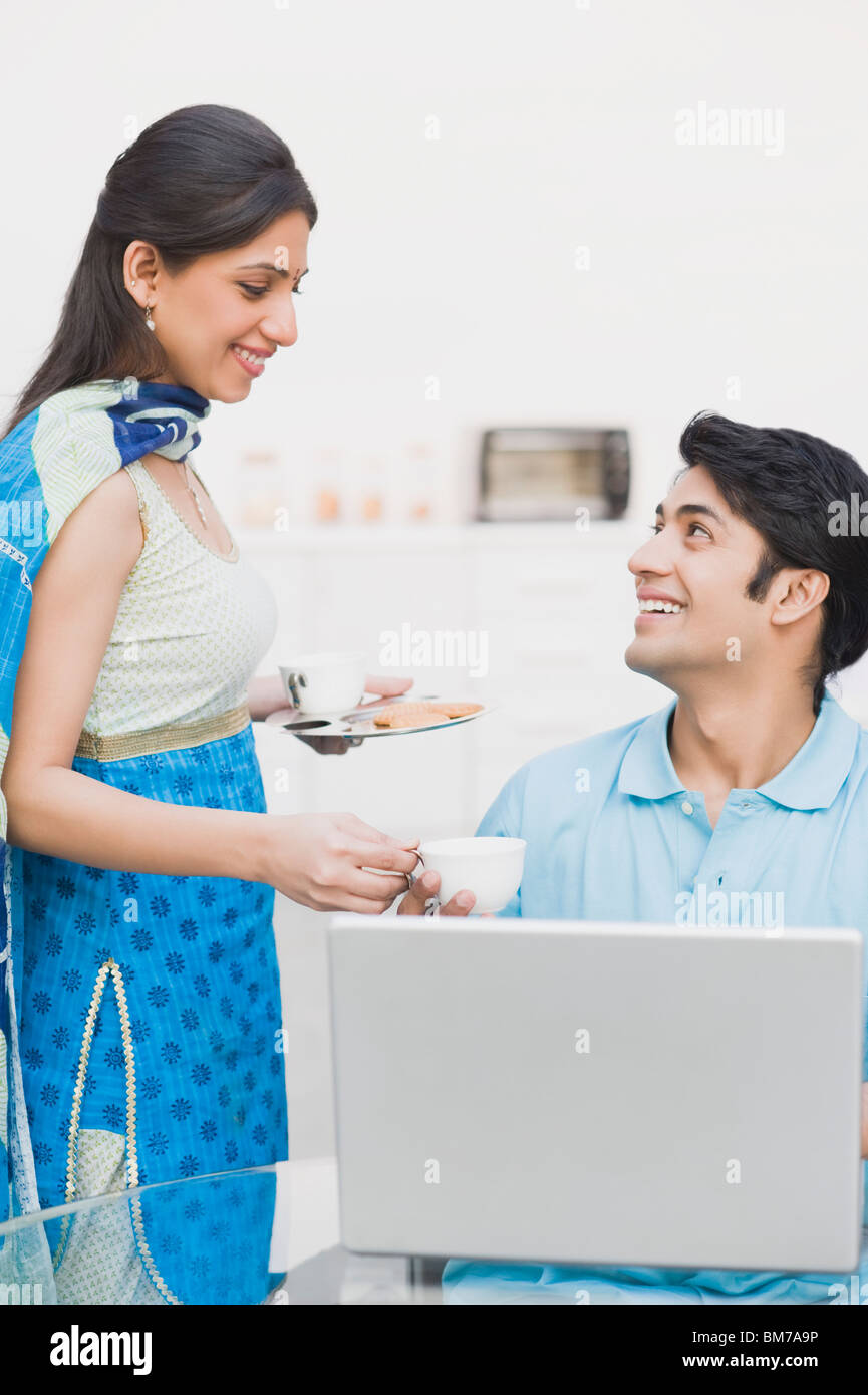 Woman giving tea to her husband Stock Photo - Alamy
