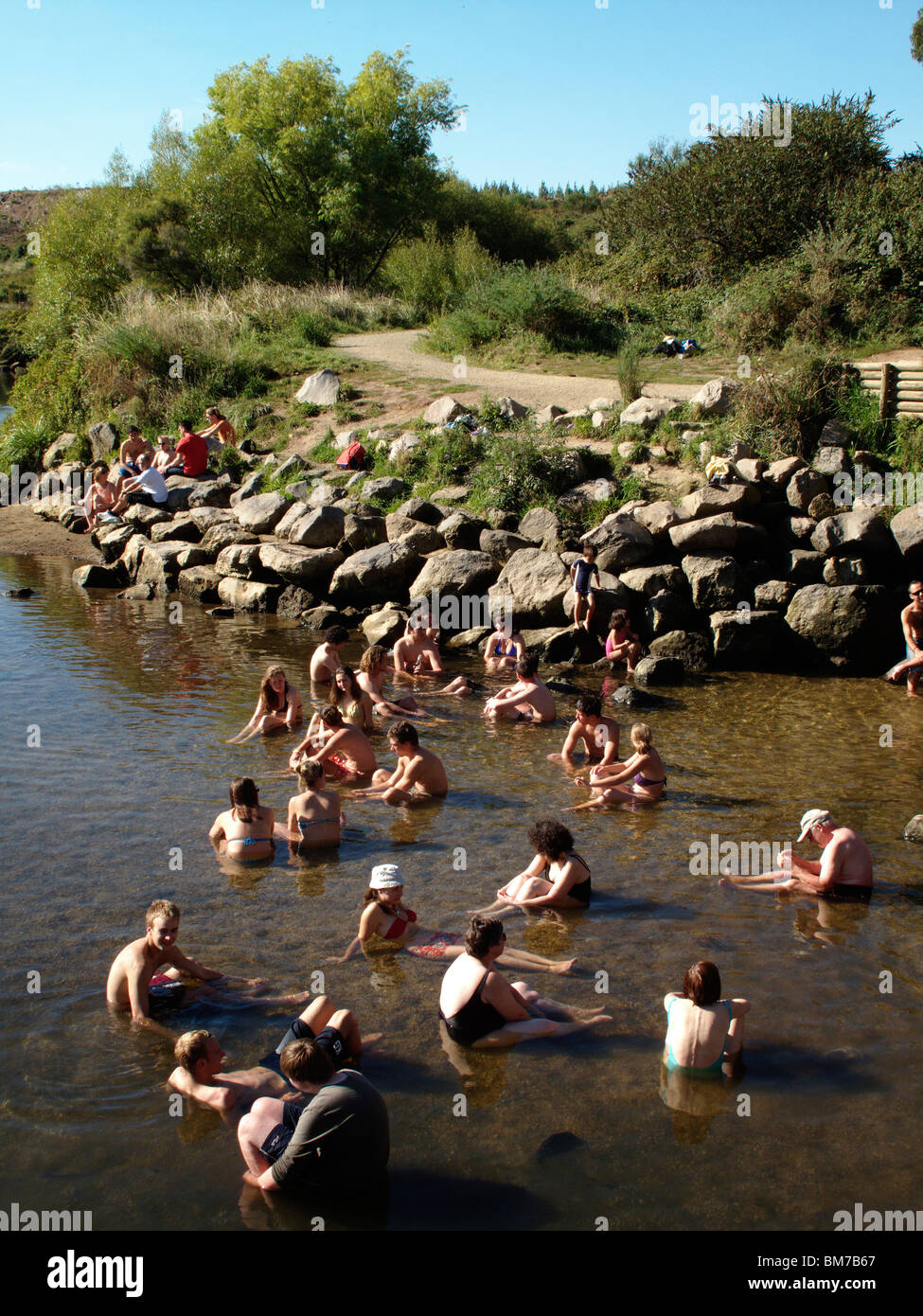 People bathing in a thermal spring on the edge of the Waikato River in ...