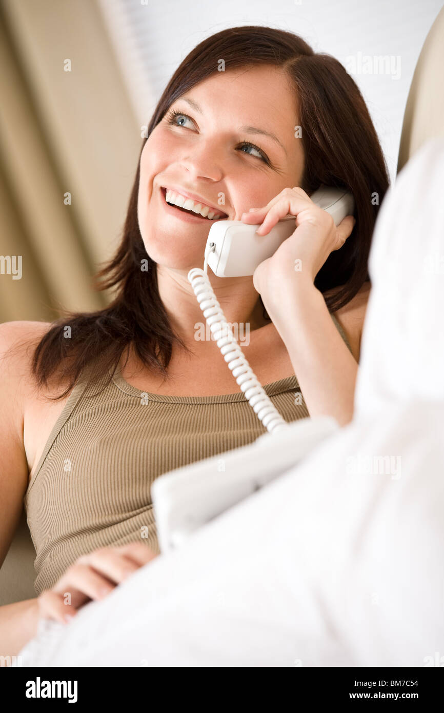 On the phone home: Smiling woman calling looking up Stock Photo - Alamy