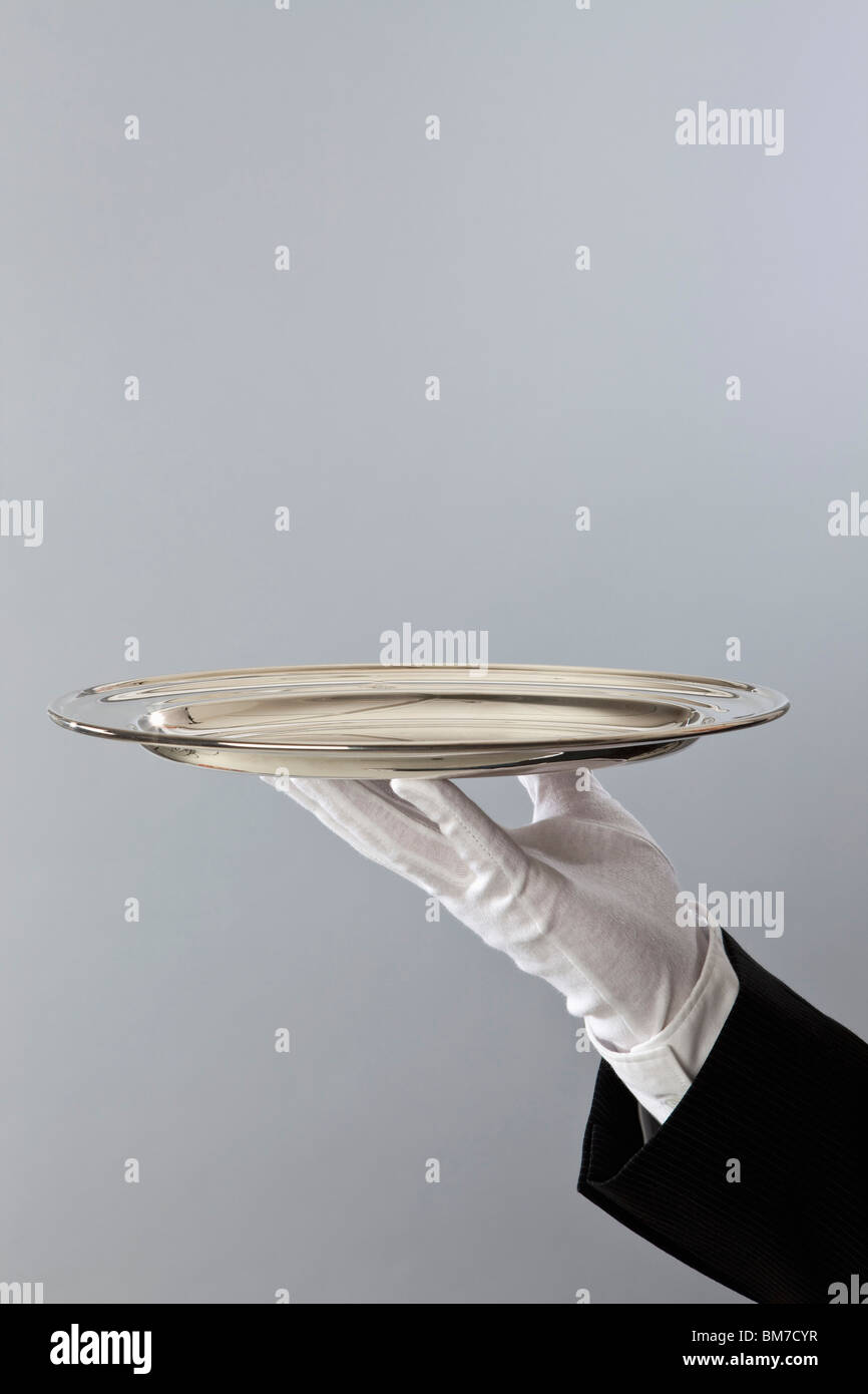 Detail of a butler holding a silver platter Stock Photo - Alamy