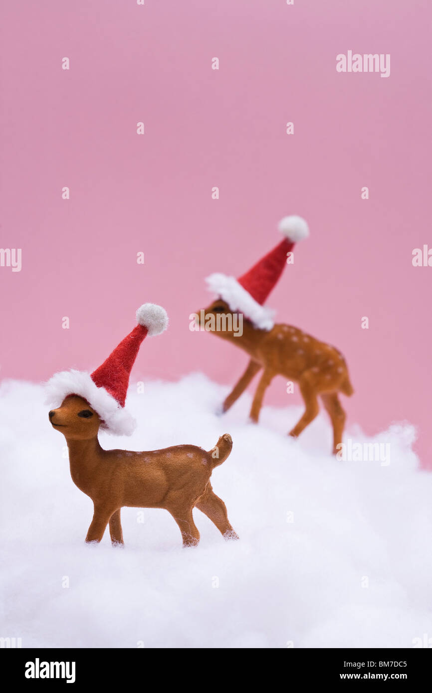 Two reindeer figurines standing in fake snow made out of cotton filling ...