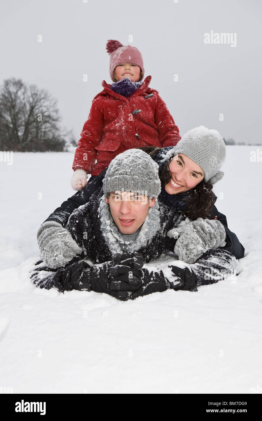 A family of three playing the in the snow Stock Photo - Alamy