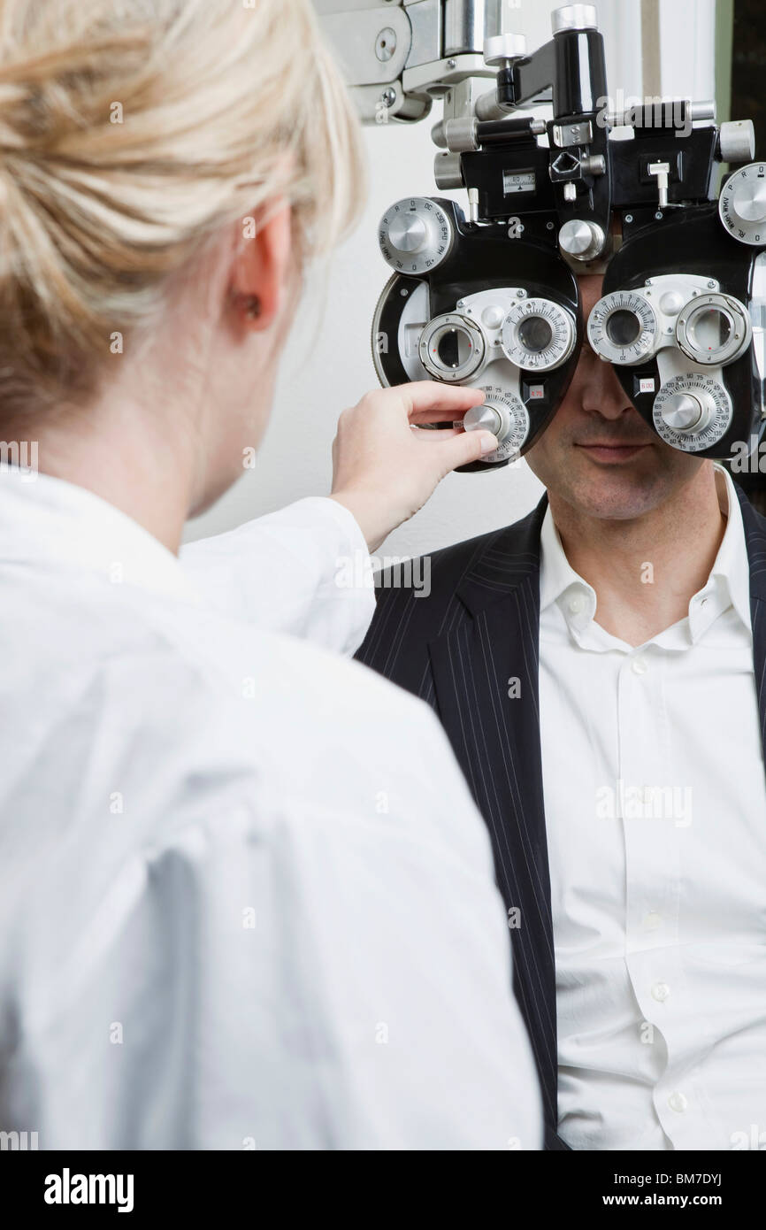 An optometrist conducting an eye exam on a man Stock Photo - Alamy