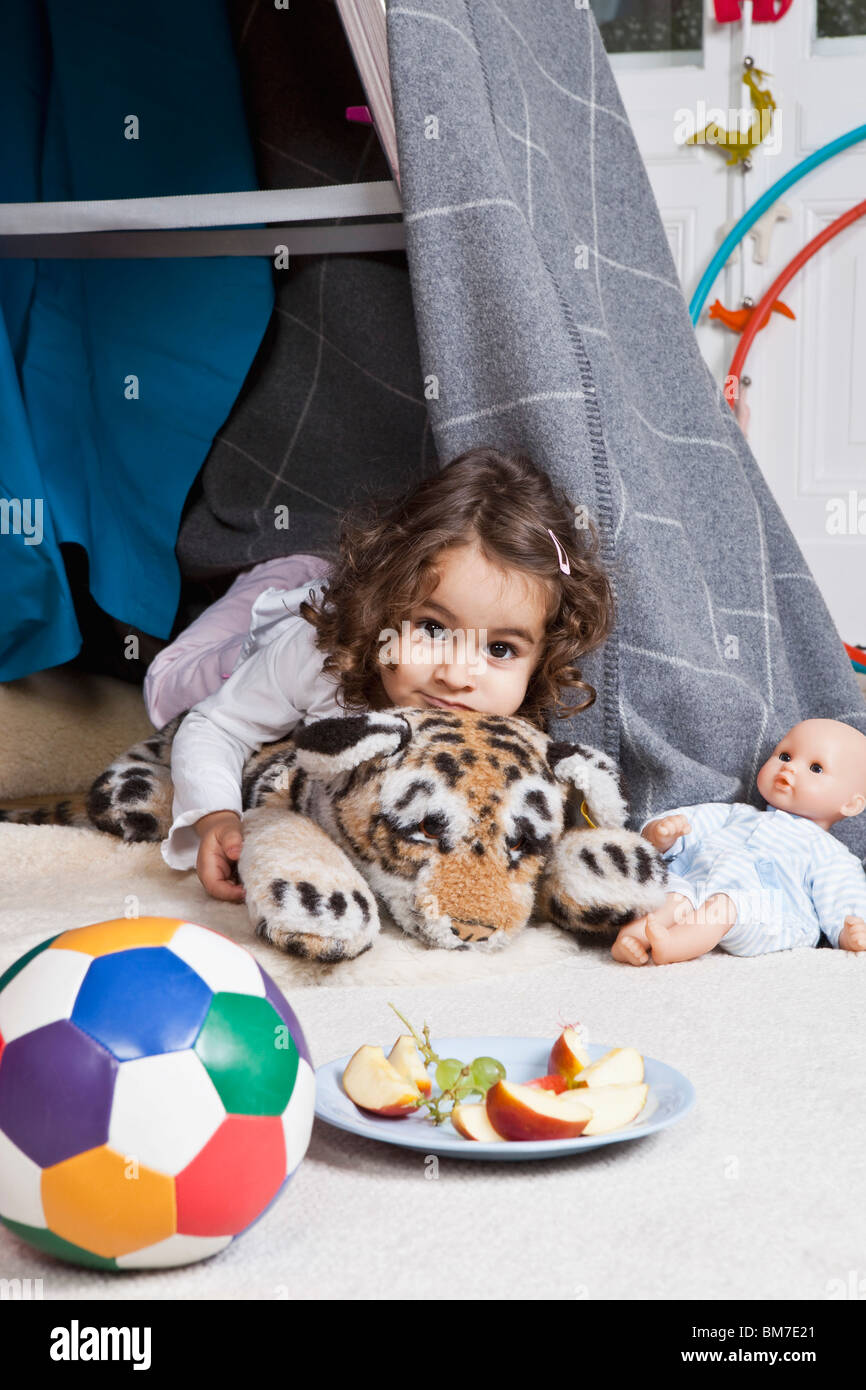 A young girl playing with a stuffed animal in a fort Stock Photo - Alamy