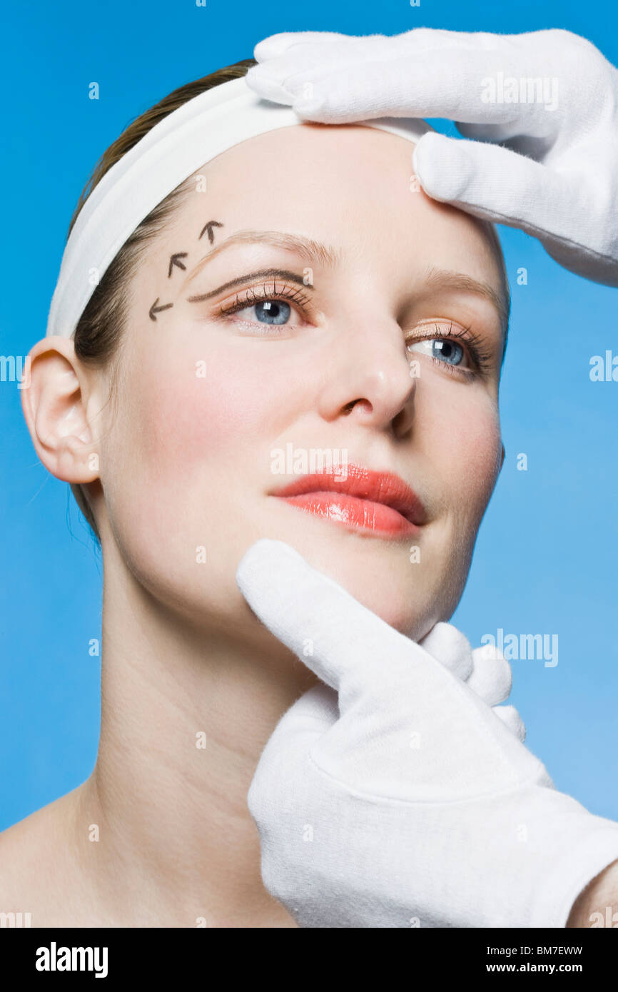 A healthcare worker, detail of hands, preparing a woman for plastic ...