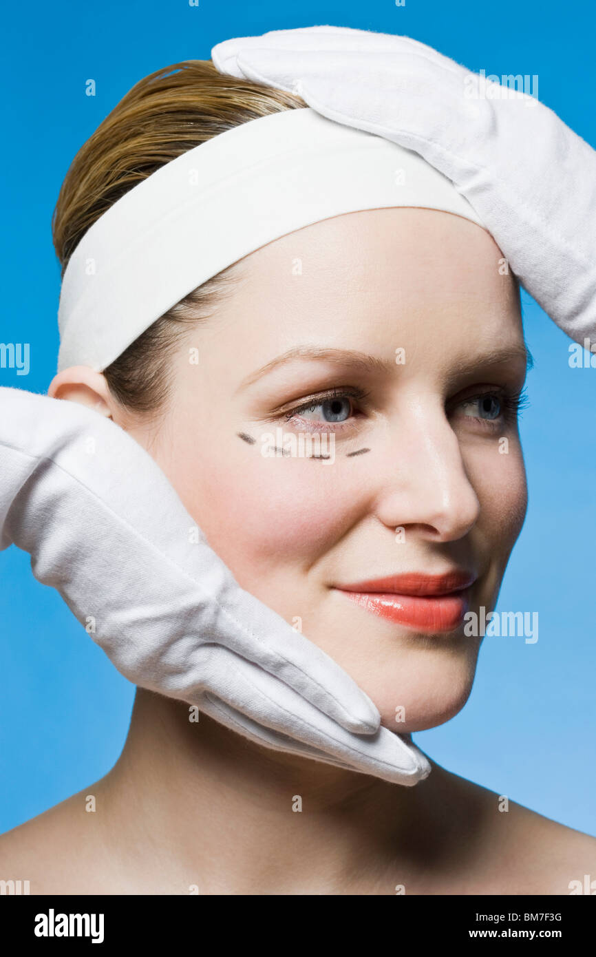 A healthcare worker, detail of hands, preparing a woman for plastic ...