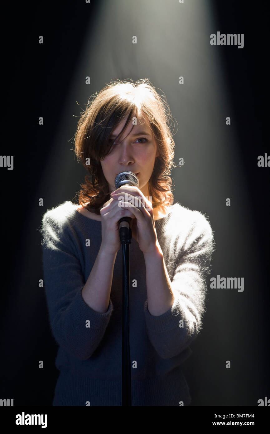 A Woman Standing Behind A Microphone Stock Photo - Alamy