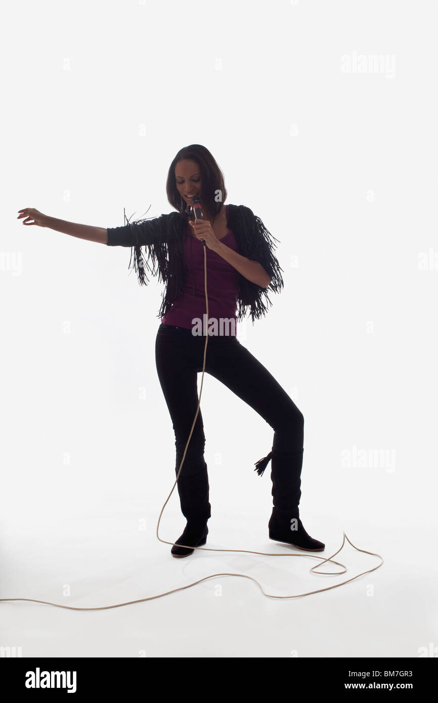 A female singer performing, studio shot, white background, back lit ...