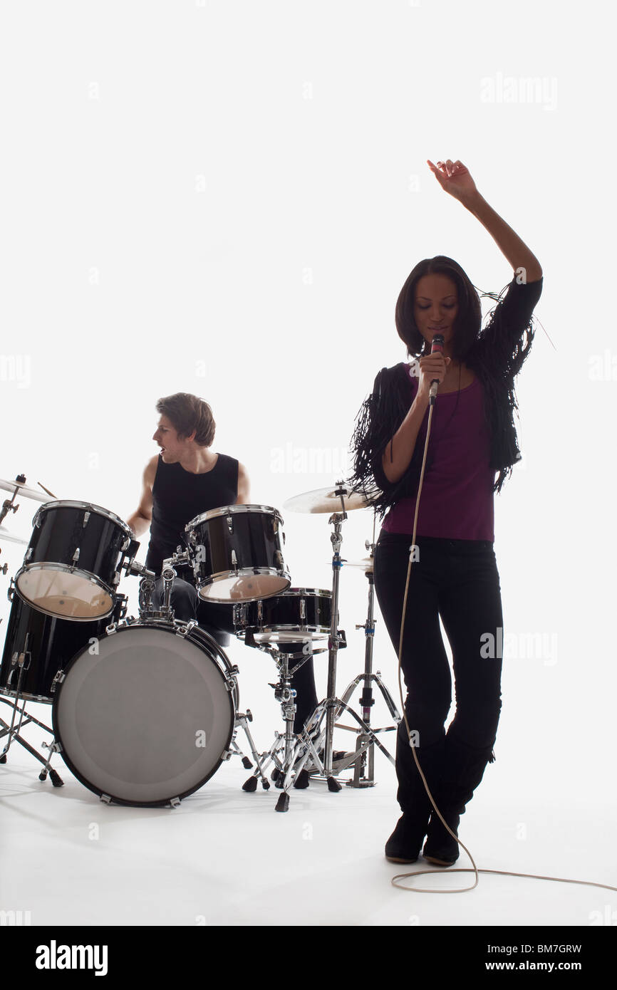 A female singer and a drummer performing, studio shot, white background ...