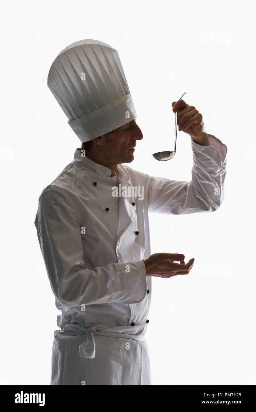 A chef holding a ladle up to his mouth, portrait Stock Photo - Alamy