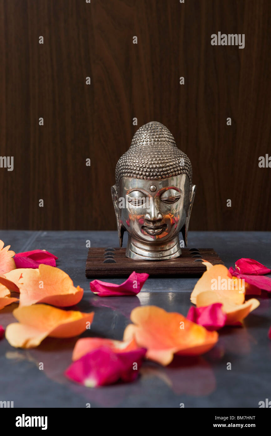 A Buddha head statue and rose petals Stock Photo - Alamy
