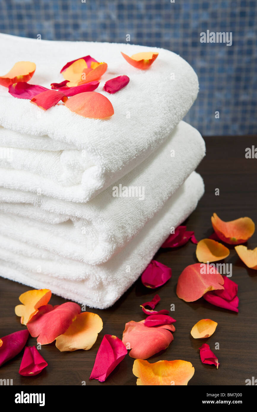A stack of folded towels with rose petals Stock Photo - Alamy
