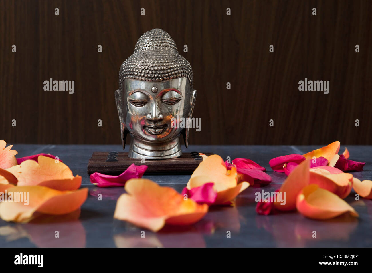 A Buddha head statue and rose petals Stock Photo - Alamy