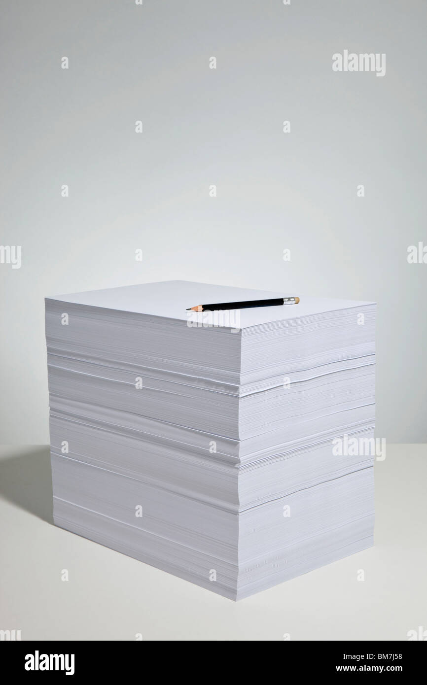 A pencil on a stack of paper Stock Photo - Alamy