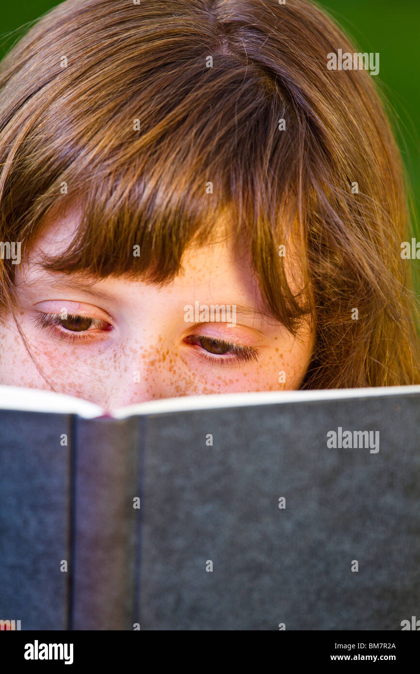 Young beautiful girl reading a book outdoor Stock Photo - Alamy