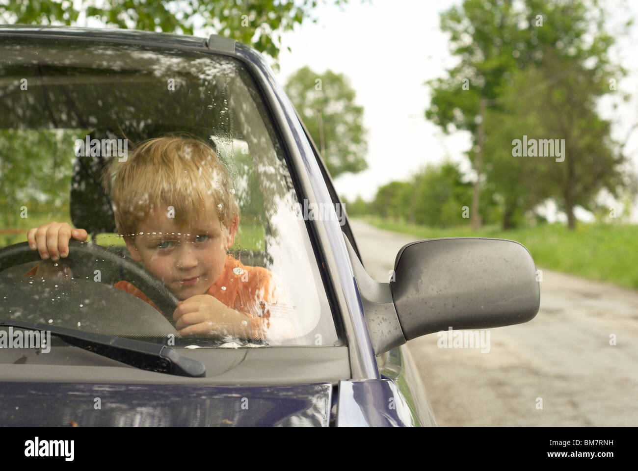 Child blond boy driving - playing with real car Stock Photo - Alamy