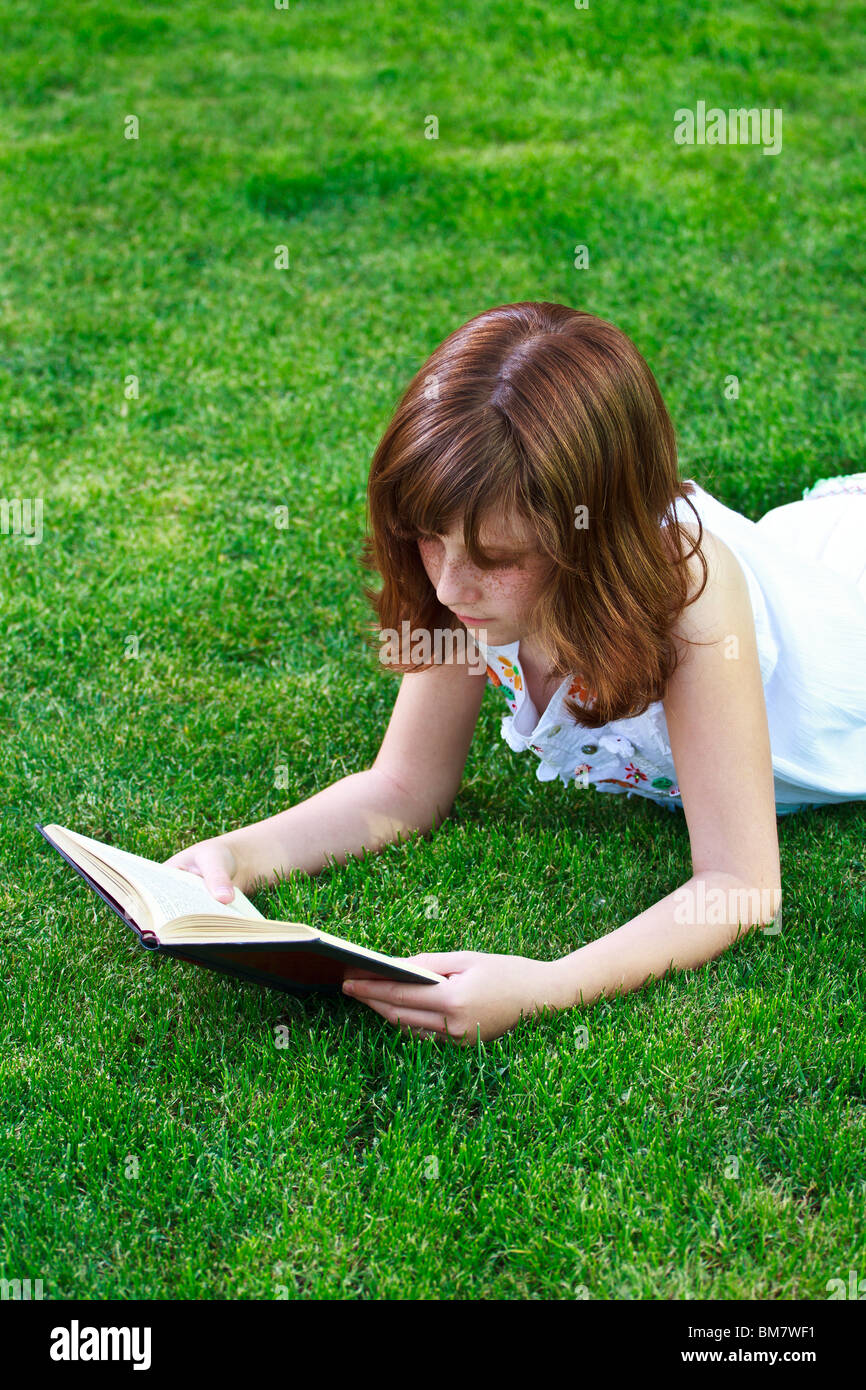 Young beautiful girl reading a book outdoor Stock Photo - Alamy