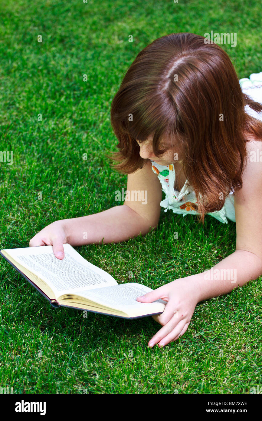Young beautiful girl reading a book outdoor Stock Photo - Alamy