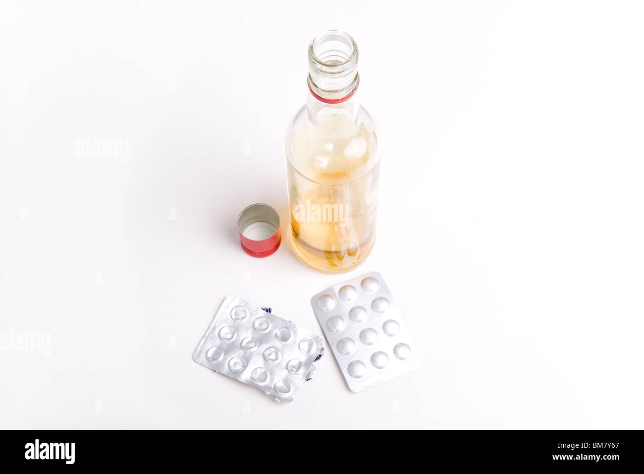 Bottle of alcohol and packs of pills Stock Photo - Alamy