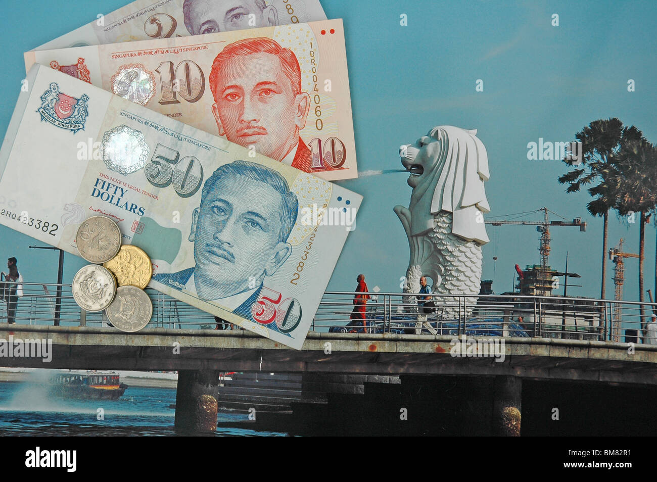 Singapore currency displayed lying on printed photo of the Merlion ...