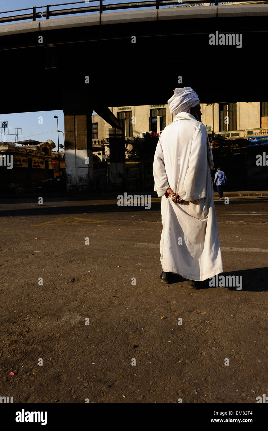 man in traditional white thawb(thobe) standing out.....street scene ...